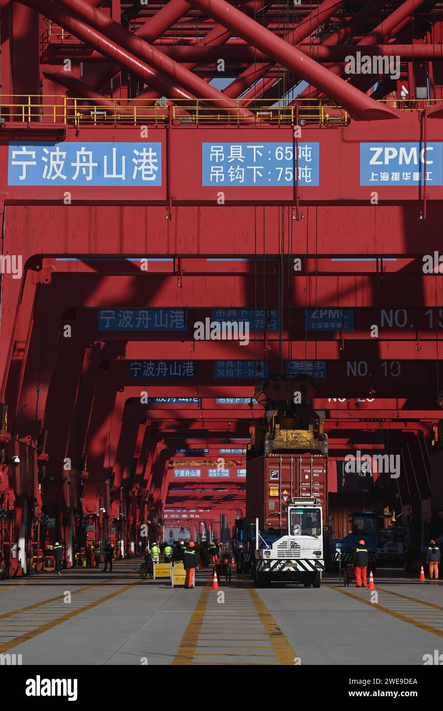 (240124) -- NINGBO, Jan. 24, 2024 (Xinhua) -- Cranes and trucks work at ...
