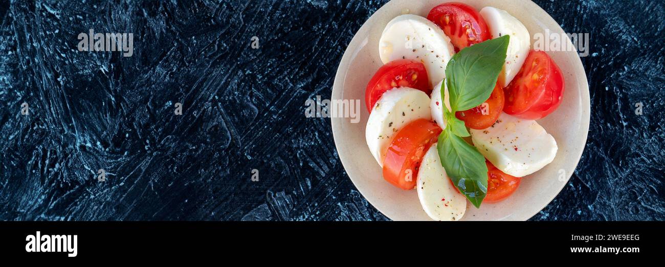 banner of caprese salad on a round plate. slices of juicy red tomato ...