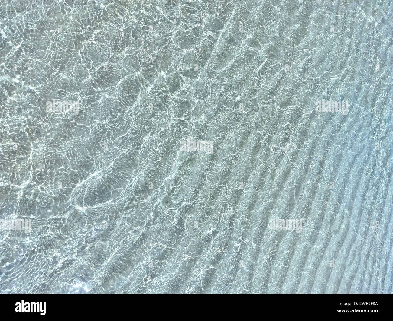 Water ripple over sandy beach. Transparent blue colored clear water ...