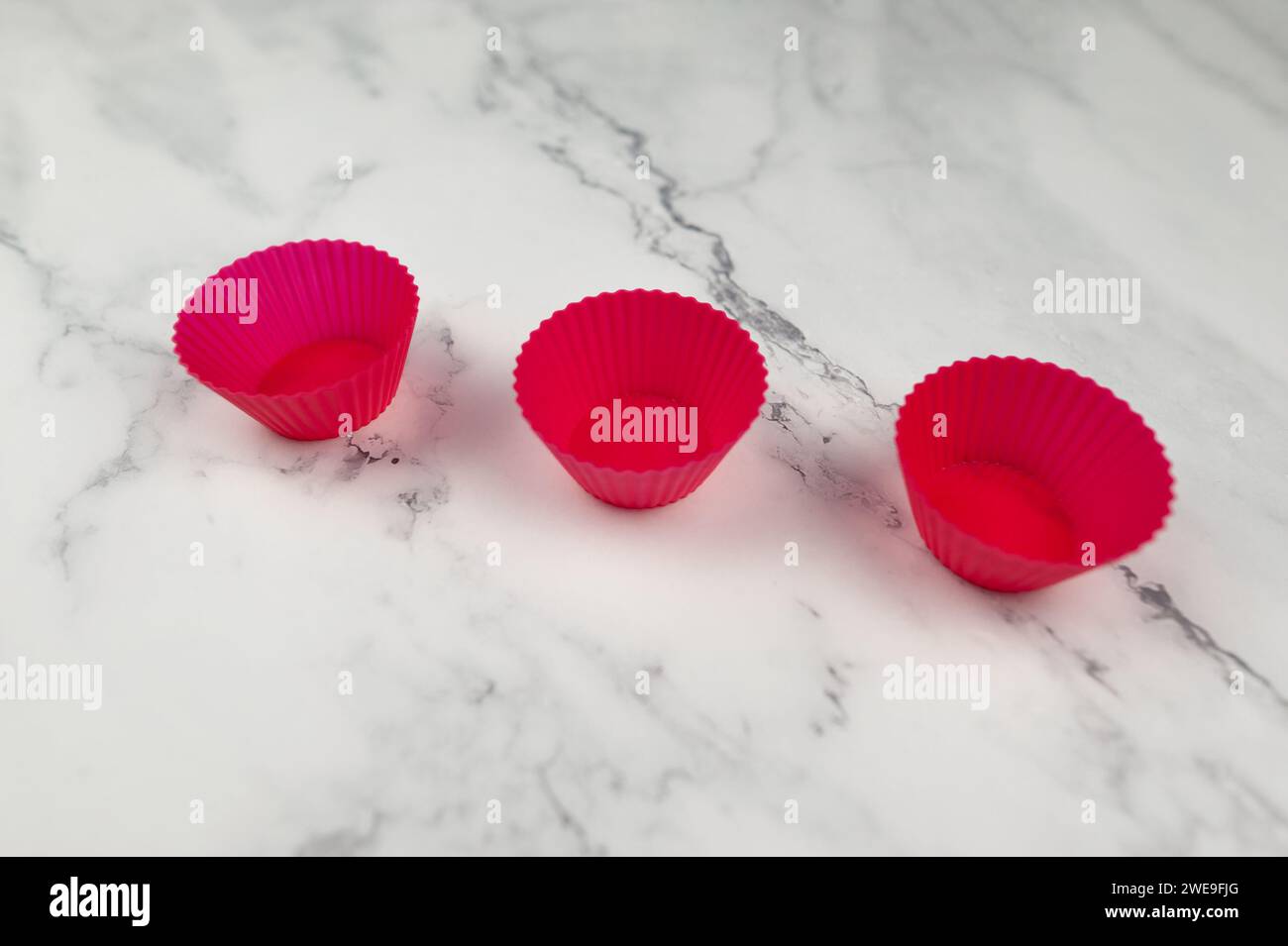 Top view of silicone cupcakes cases on white marble background. Muffins ...