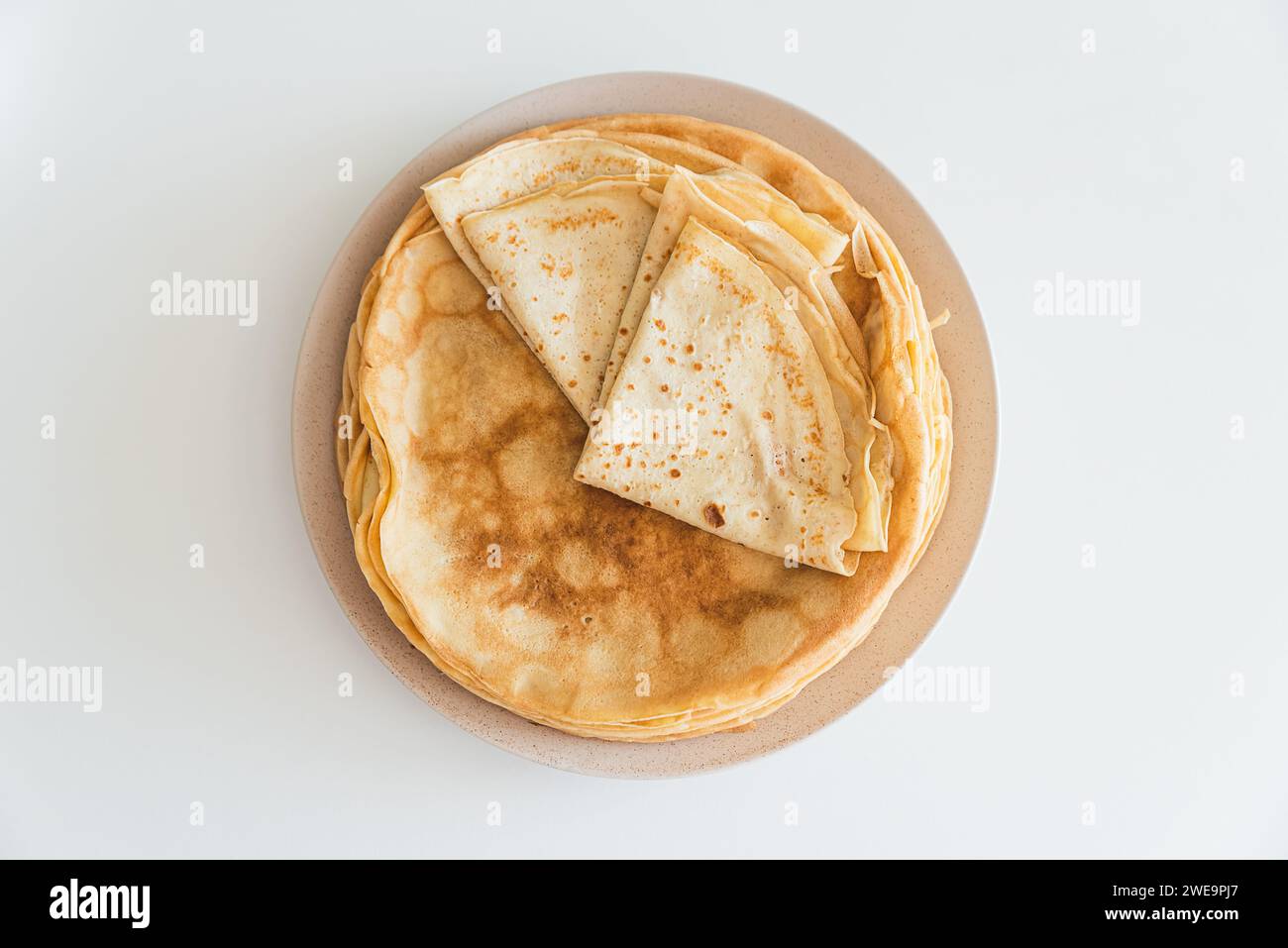 Stack of French crepes on white table. Top view Stock Photo - Alamy