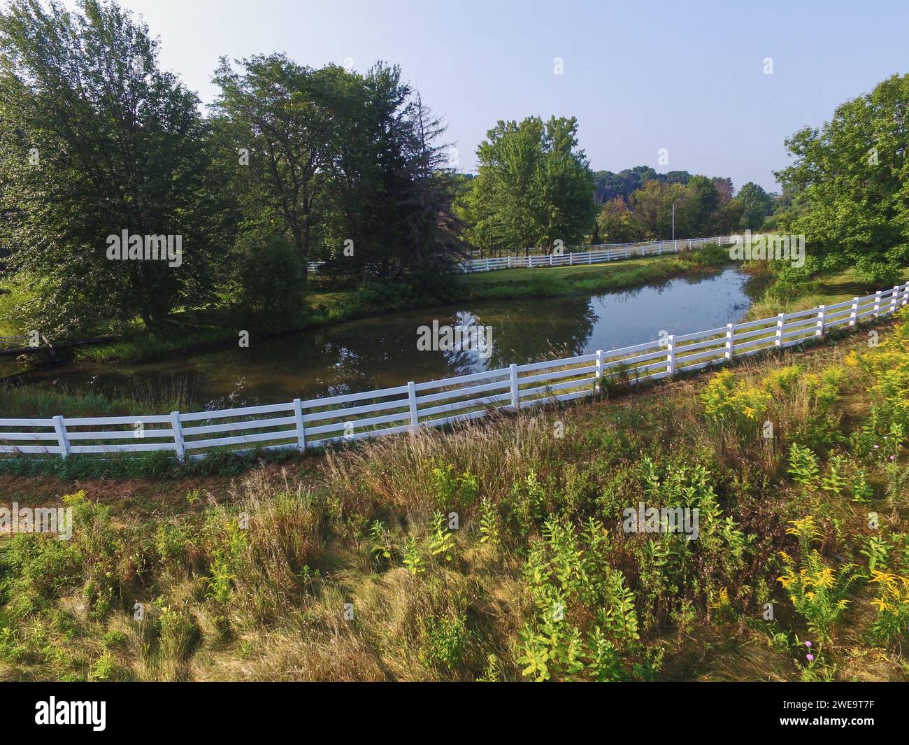 Aerial Serene Lakeside with White Fence and Lush Trees, Auburn Stock ...