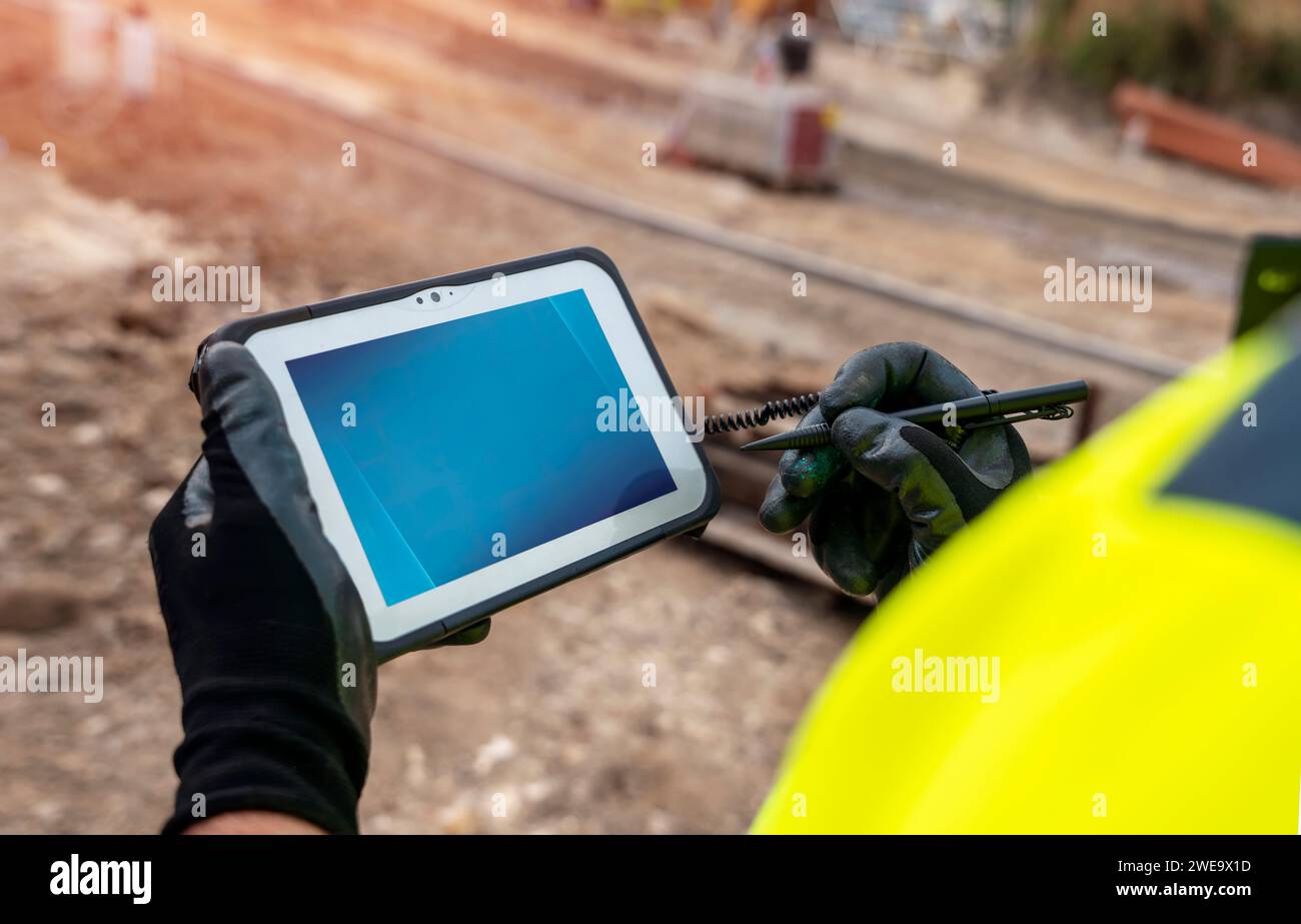 Site engineer surveyor using rugged tablet controller computer to ...