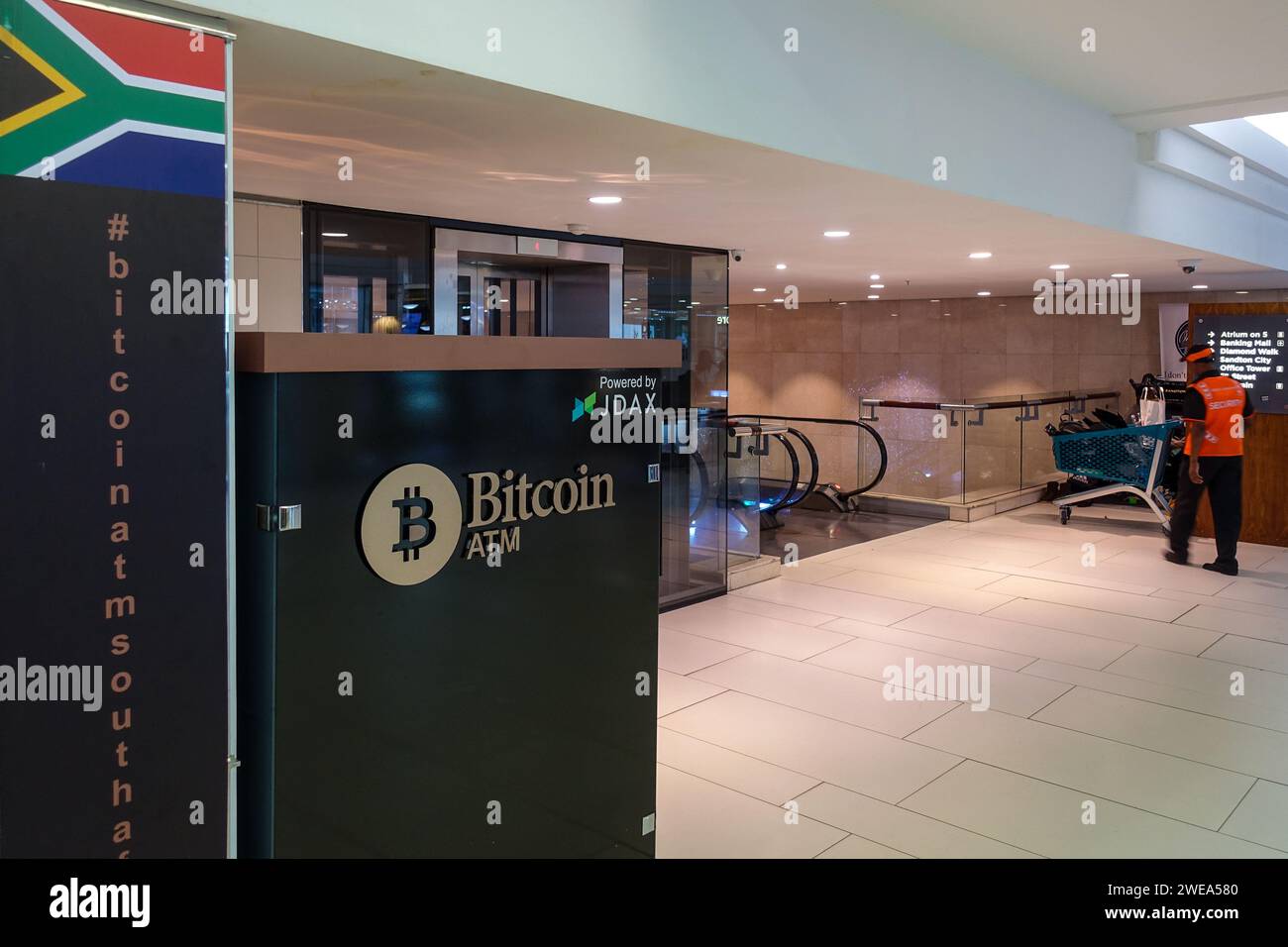 Bitcoin ATM located inside a modern commercial mall with people and ...