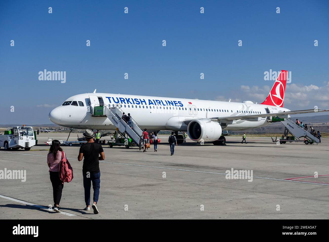 Passengers walking towards a Turkish Airlines airplane on the tarmac of ...