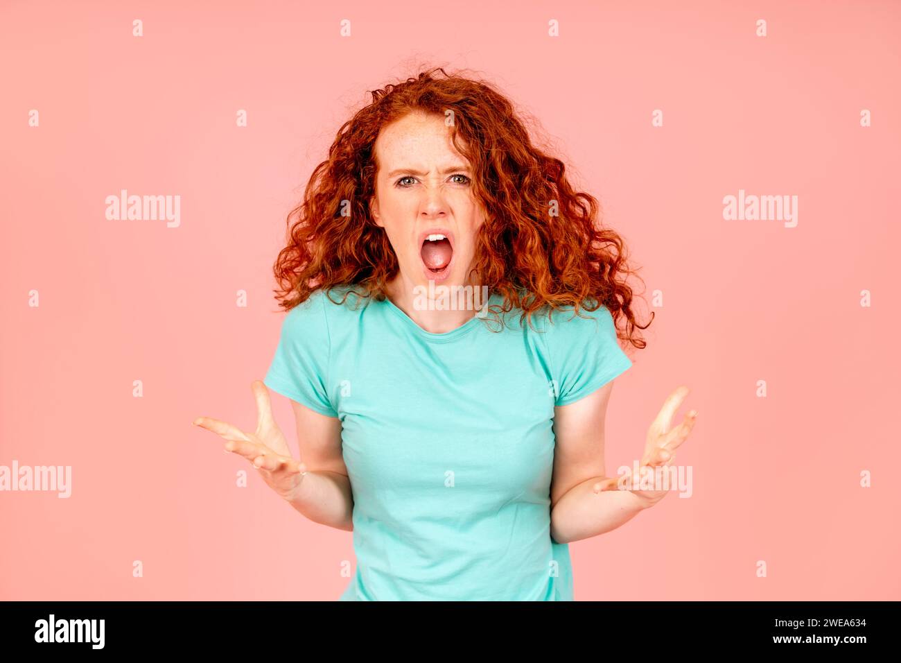 Angry young red hair woman with curly wavy hair with closed ears in ...