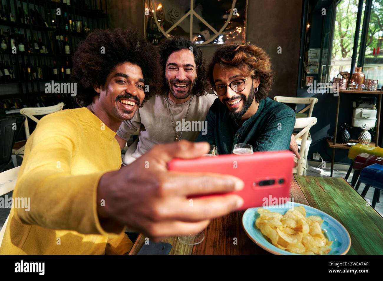 Three multiracial friends celebrating together hi-res stock photography ...