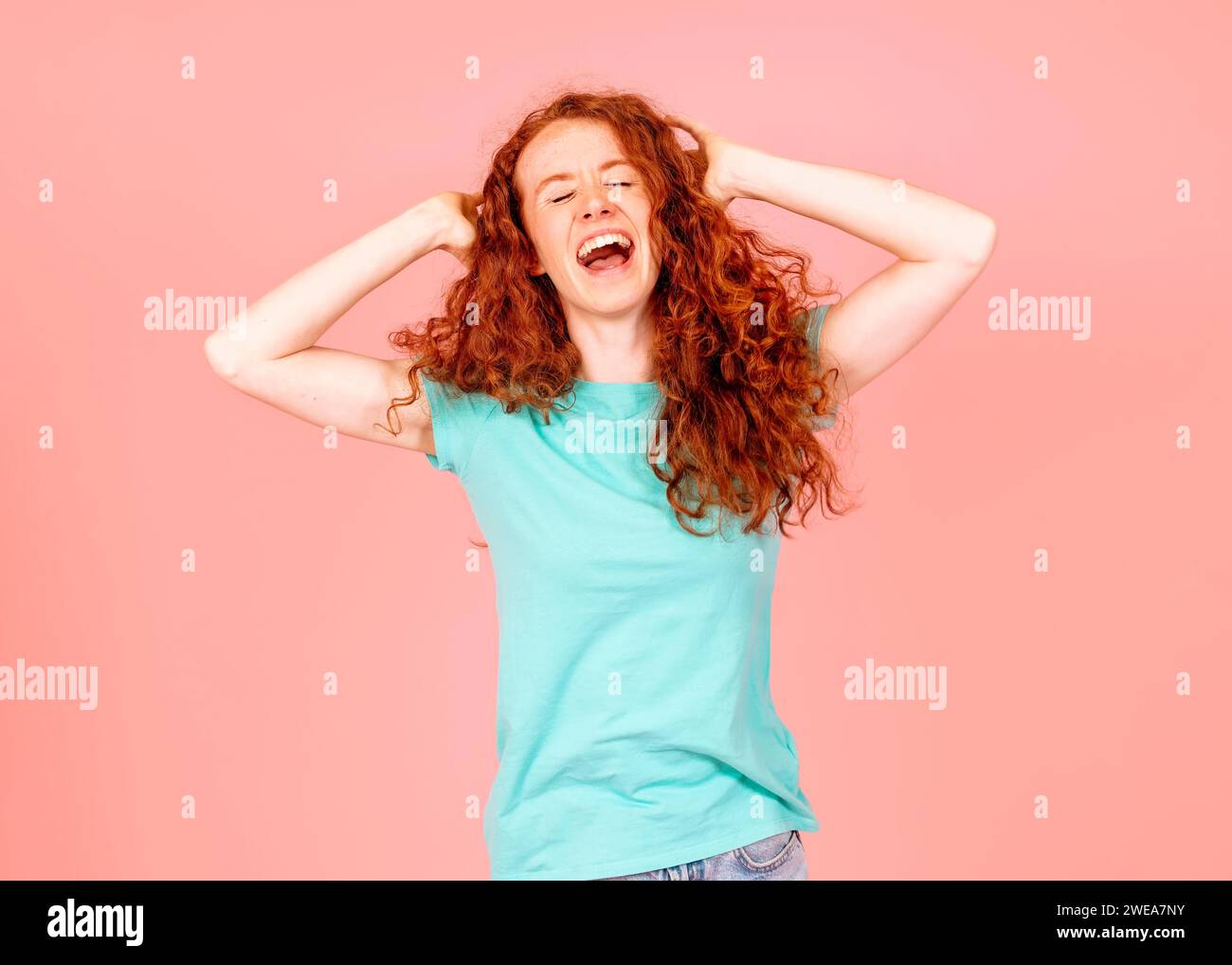 Screaming young red hair woman with curly wavy hair with closed ears in ...