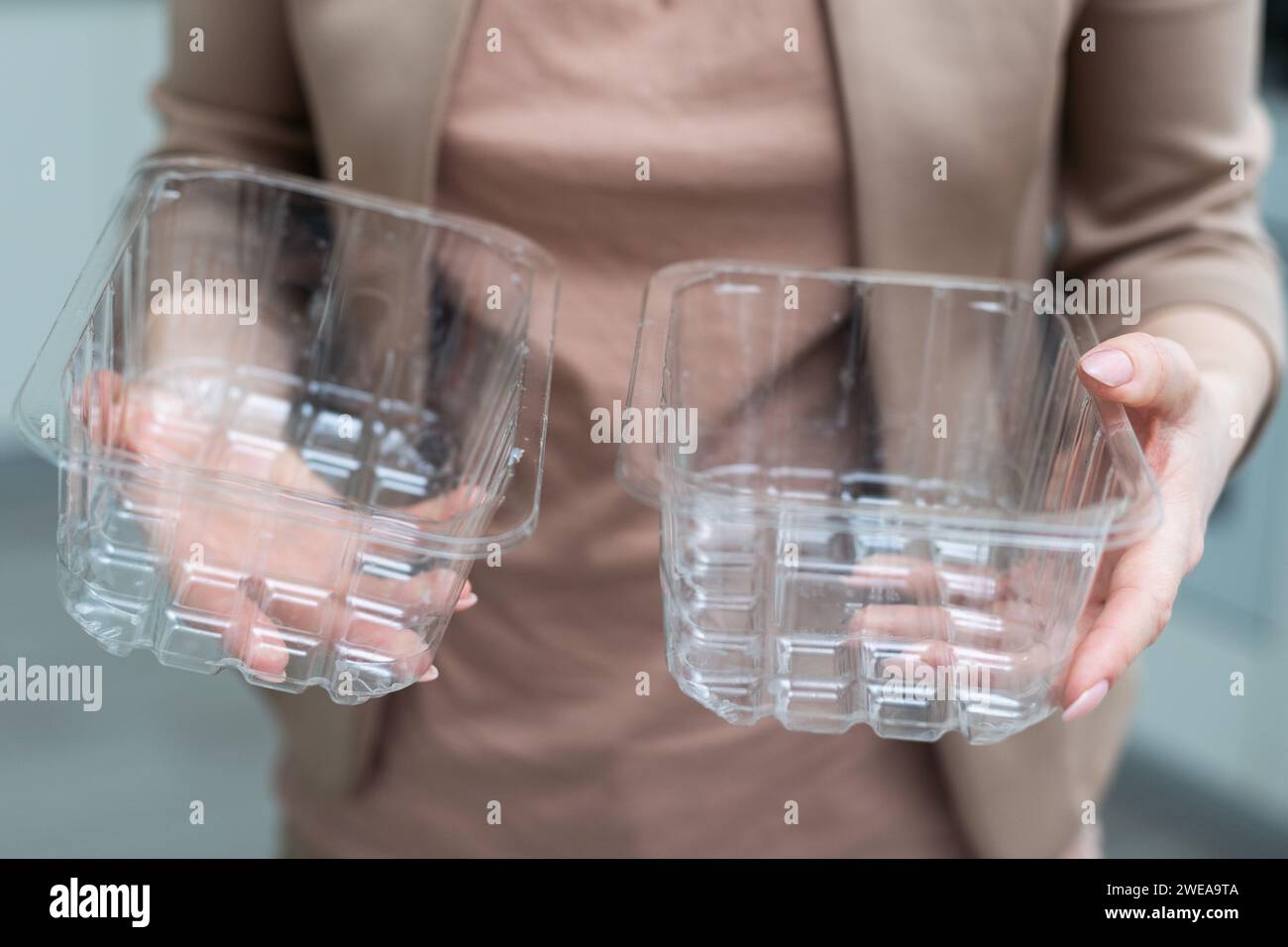 Close up hand holding empty plastic containers on white background. hand throwing empty plastic ...