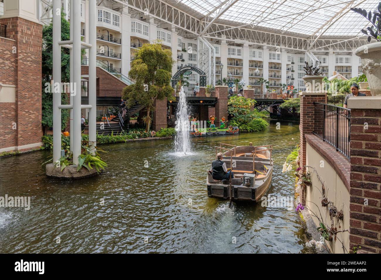 Guide piloting boat through the canal inside the Gaylord Opryland ...