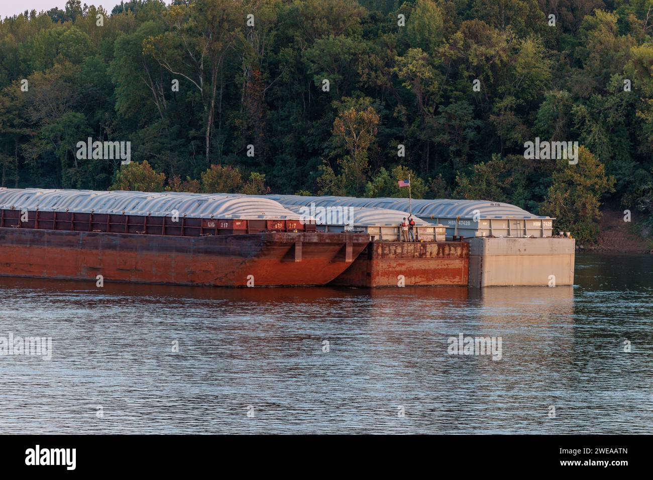 Deck hands place the American flag on a barge being pushed on the ...