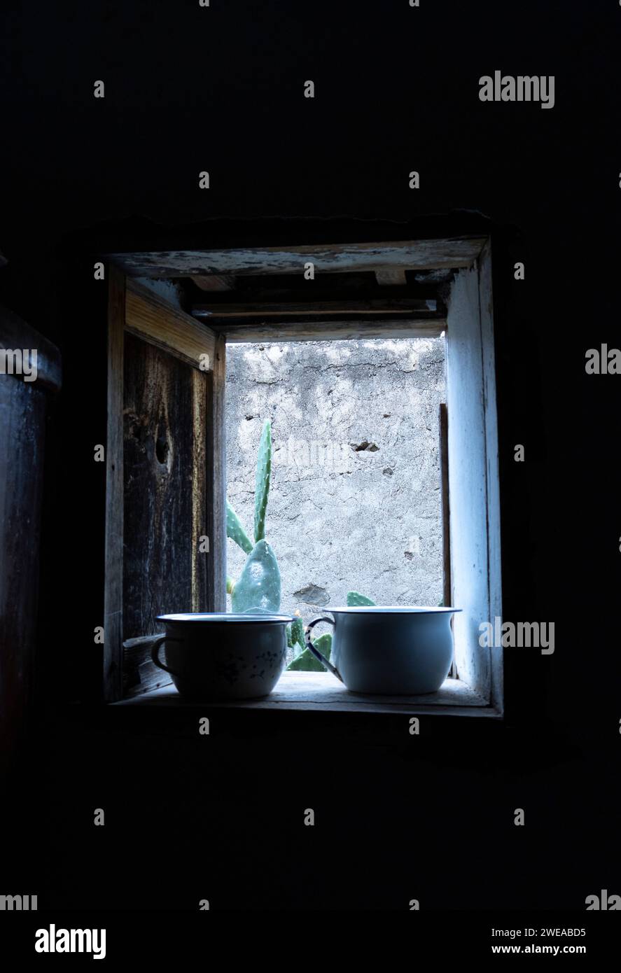 view of an old window from inside the house with old metal chamber pots ...
