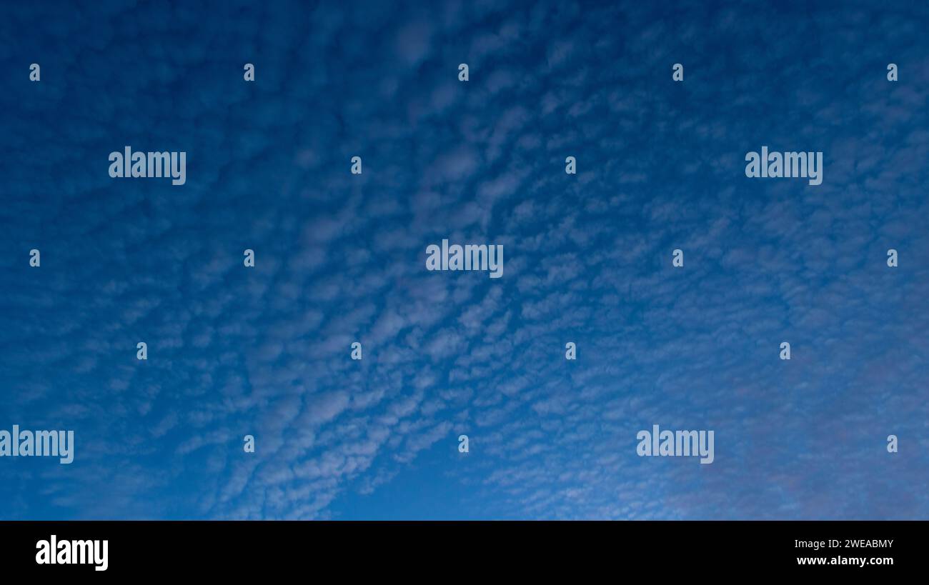 Blue sky with high cumulus clouds resembling irregular flakes Stock ...