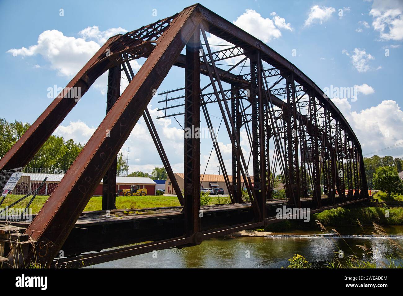 Rustic Truss Bridge over River with Industrial Backdrop Stock Photo - Alamy