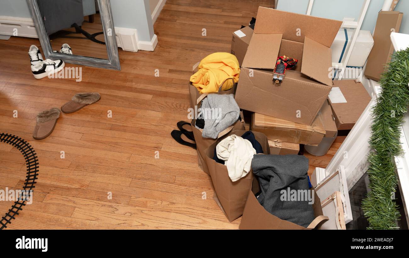 Cardboard boxes with clothes, shoes on the floor things and stuff for ...