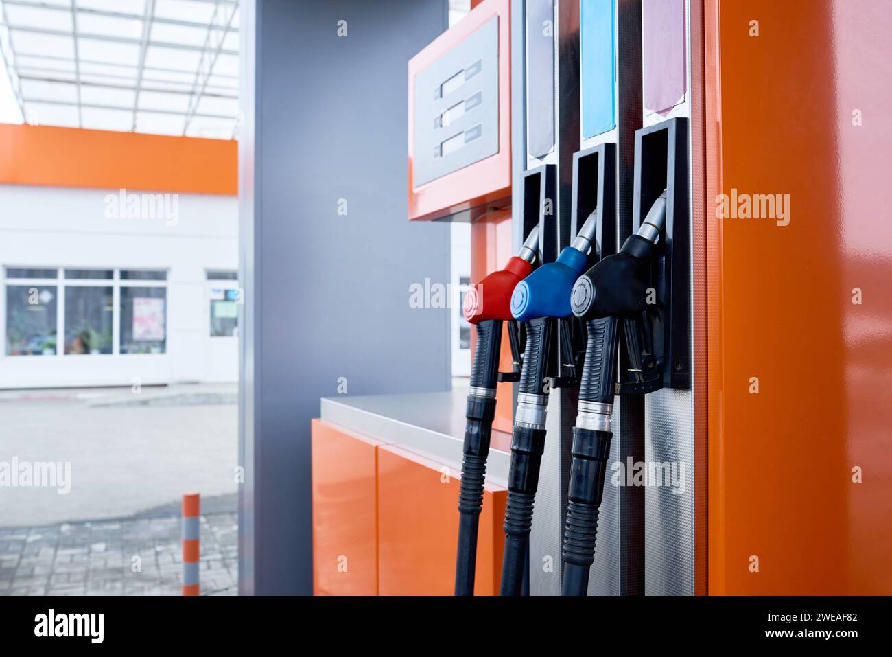 Side view background image of orange fuel pump in gas station, copy ...