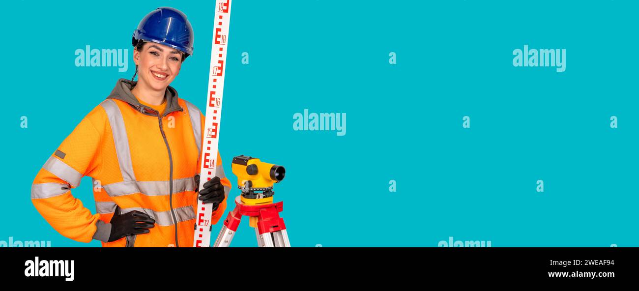 Woman in blue hard hat and yellow protective clothes land surveyor ...