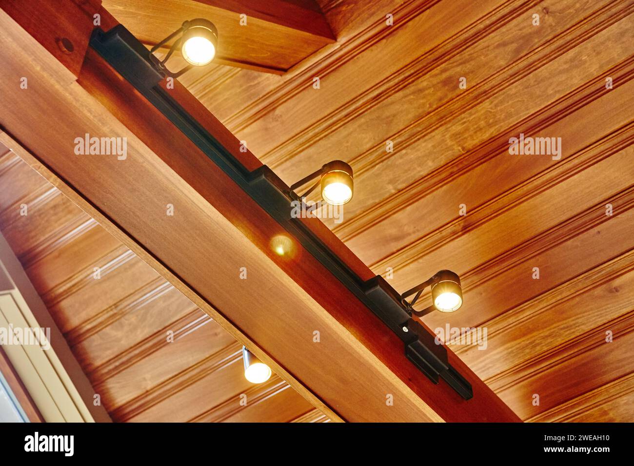 Modern Track Lighting on Wooden Ceiling with Cozy Glow Stock Photo - Alamy