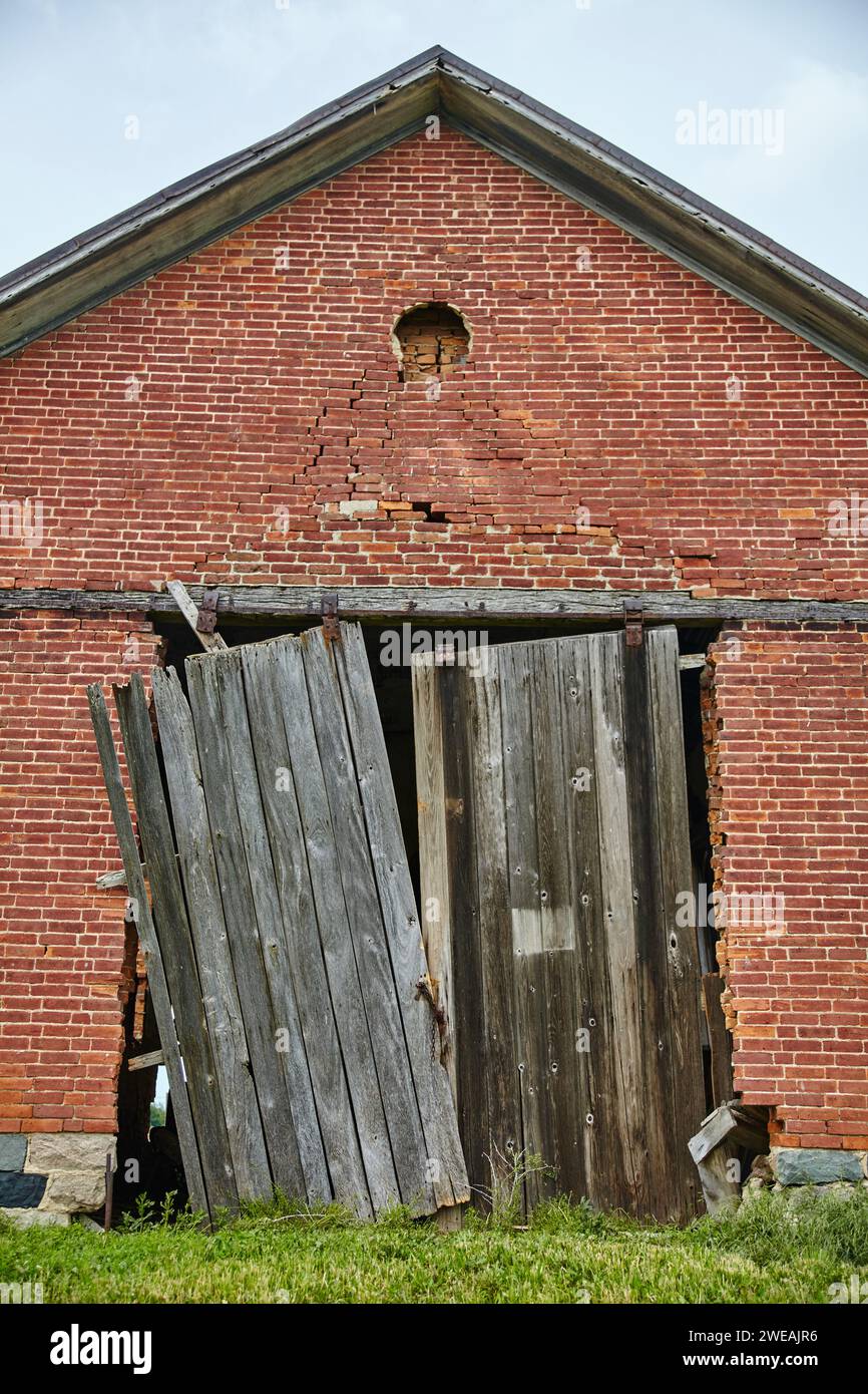 Aged Brick Building with Weathered Wooden Doors and Overgrown Grass ...