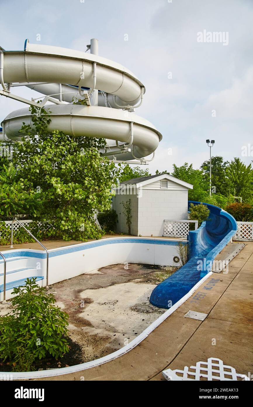 Abandoned Water Park Slide with Encroaching Greenery and Drained Pool ...