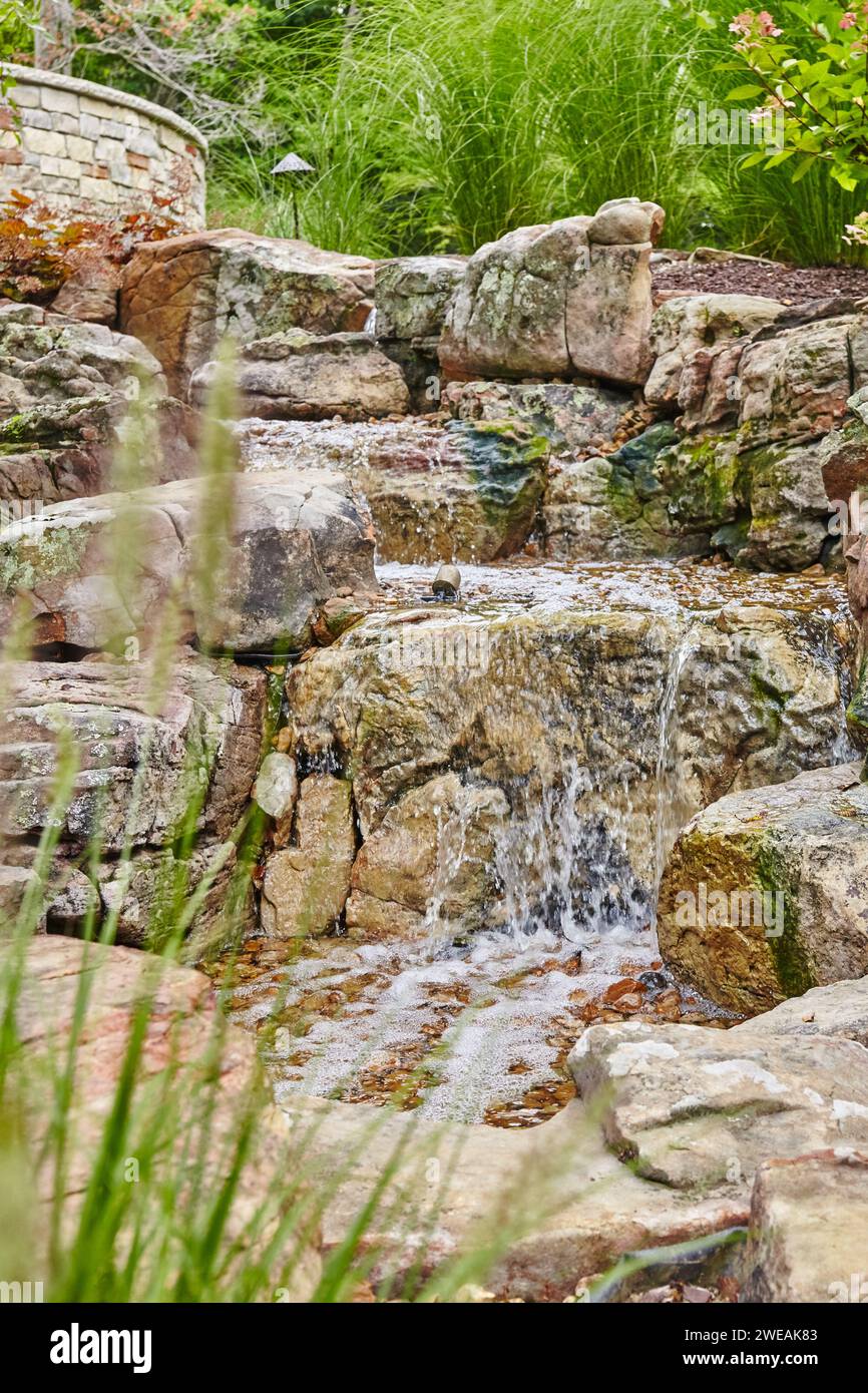 Rustic Garden Waterfall with Lush Greenery and Pebbled Pool Stock Photo ...