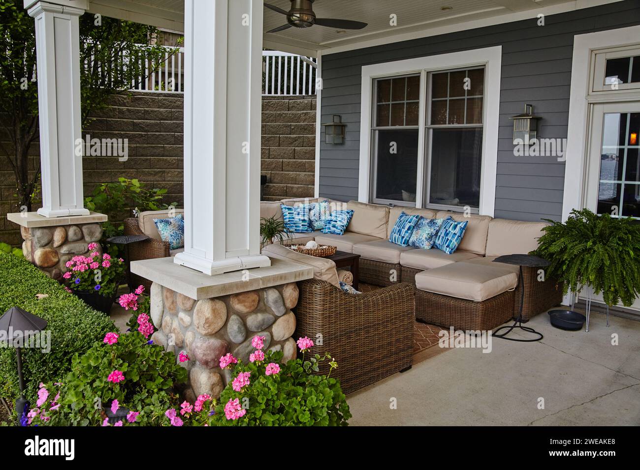 Suburban Porch with Rattan Furniture and Lush Greenery Stock Photo - Alamy