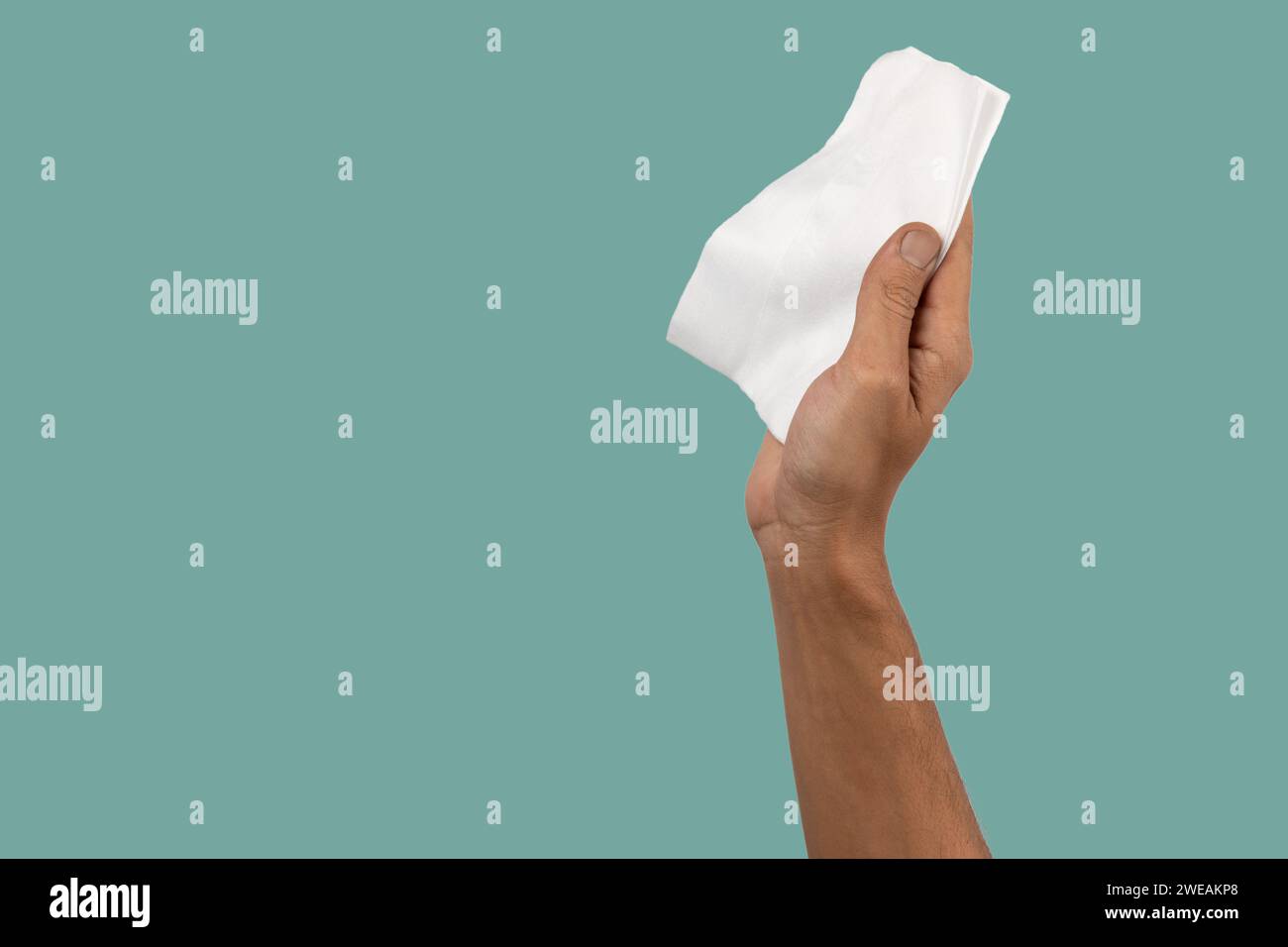 Male hand holding white cleaning cloth on green background Stock Photo ...