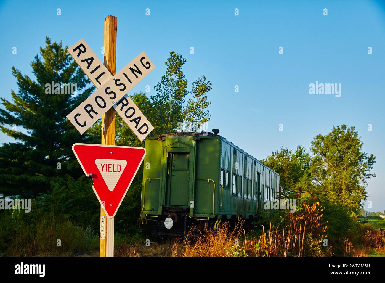 Rustic Railroad Crossing with Vintage Green Train Car and Yield Sign ...