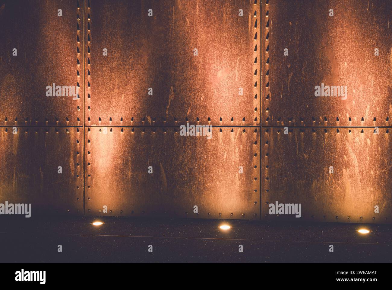 Illuminated rusting riveted metal panels at rhe historic docks at ...