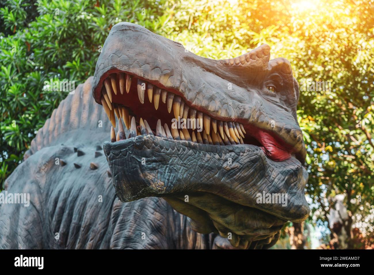 An angry predatory dinosaur in the green jungle screams and growls ...