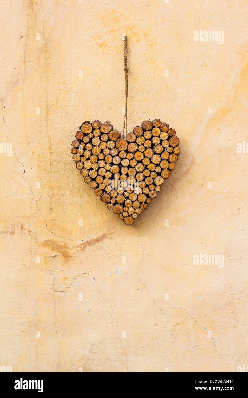 Heart shape decoration made of small wood sticks hanging on the yellow ...