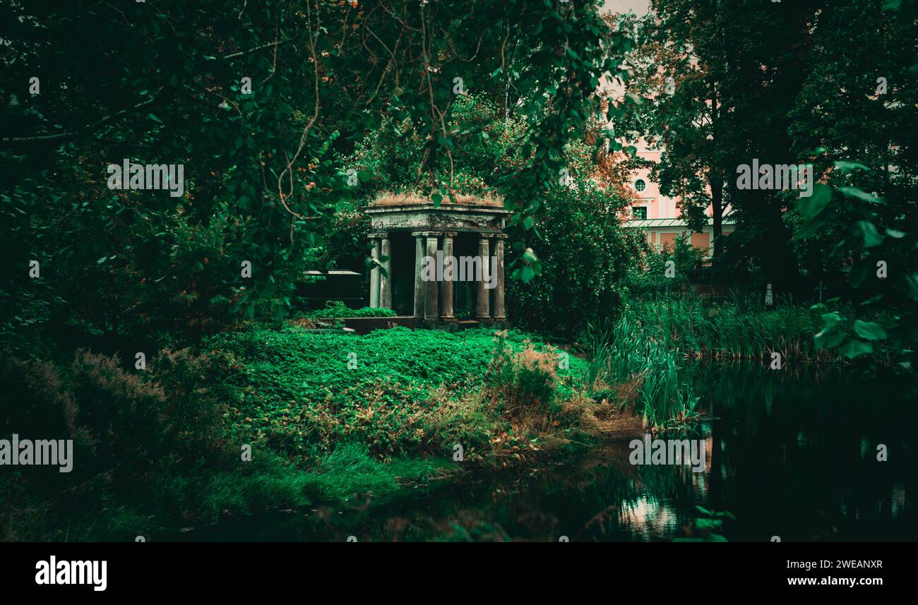 In the overgrown green garden there is an old stone crypt on a summer ...