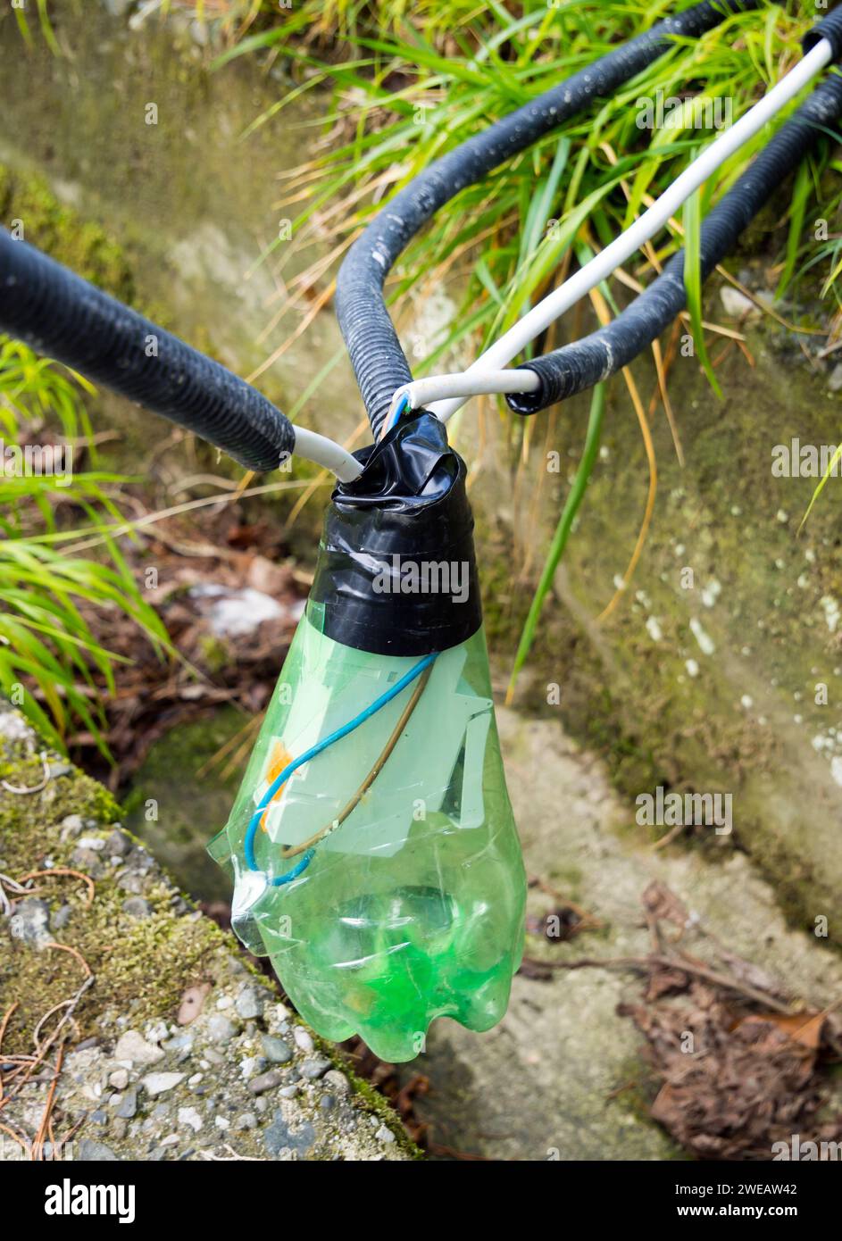 Protecting the junction of wires outdoors with a plastic bottle Stock ...