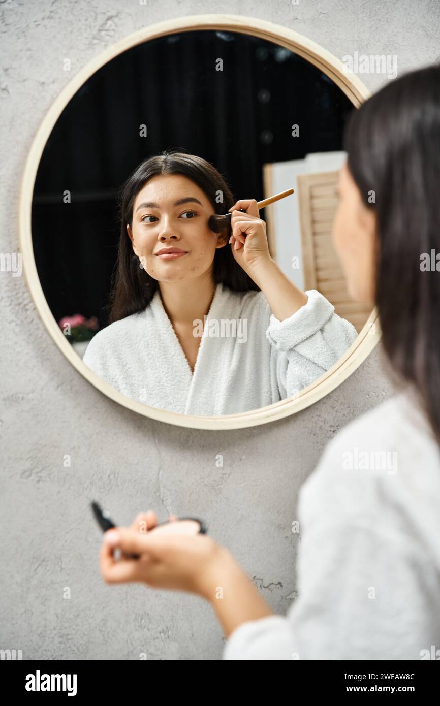 young asian woman with brunette hair and acne applying powder with ...