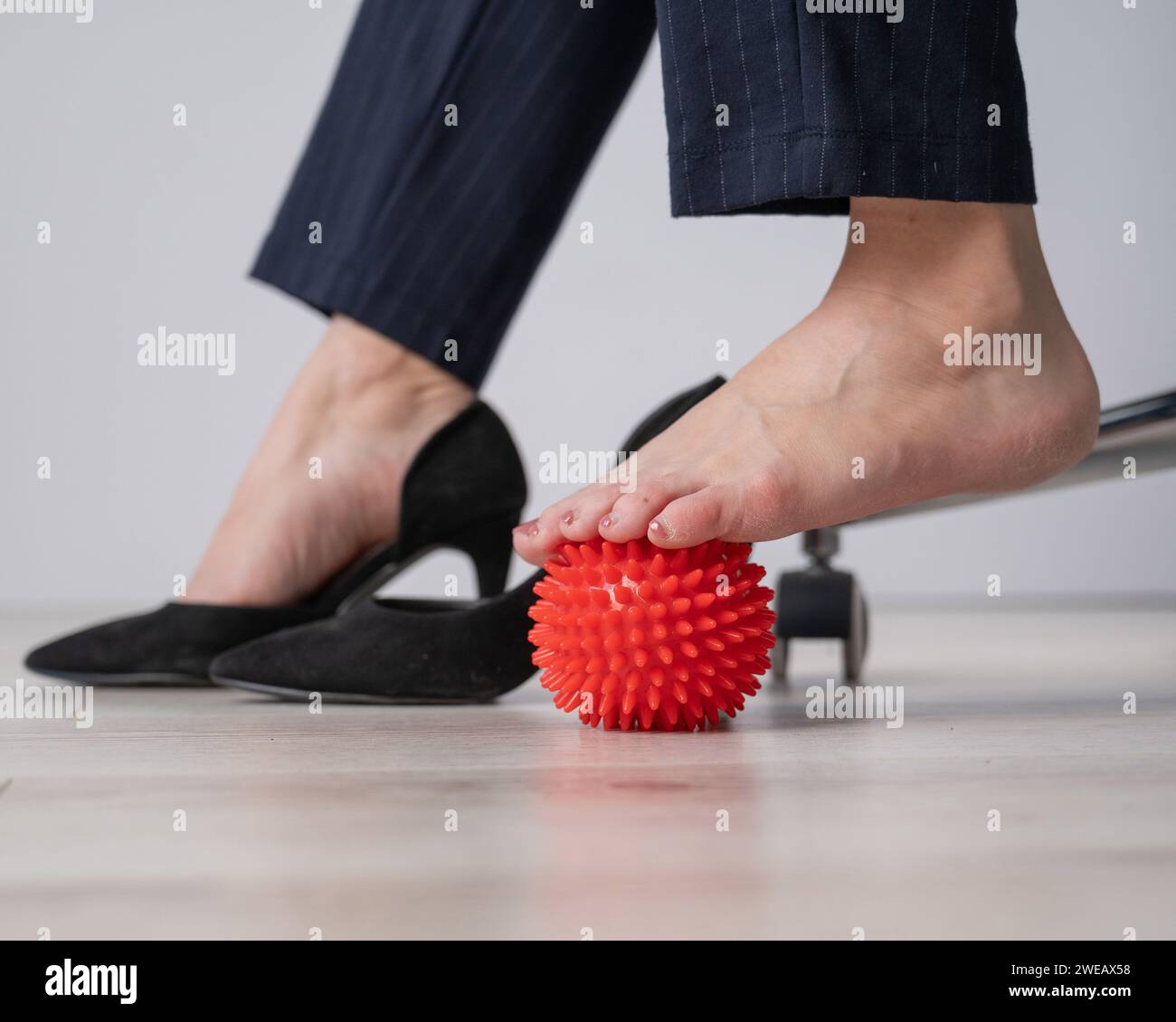 Business woman massages her feet on a massage ball with spikes Stock ...