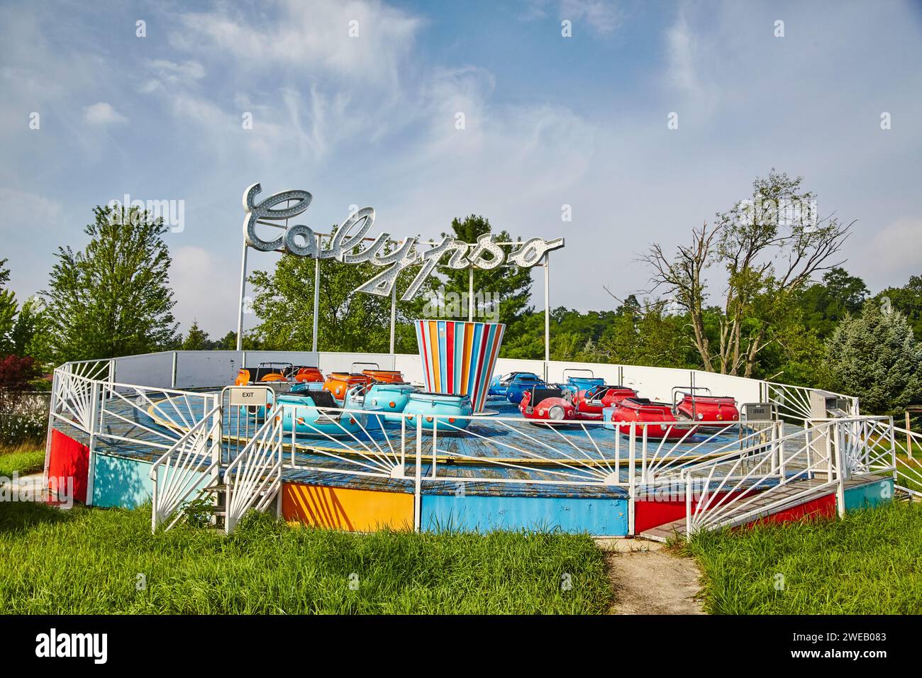 Colorful Vintage Calypso Amusement Ride with Lush Greenery Background ...