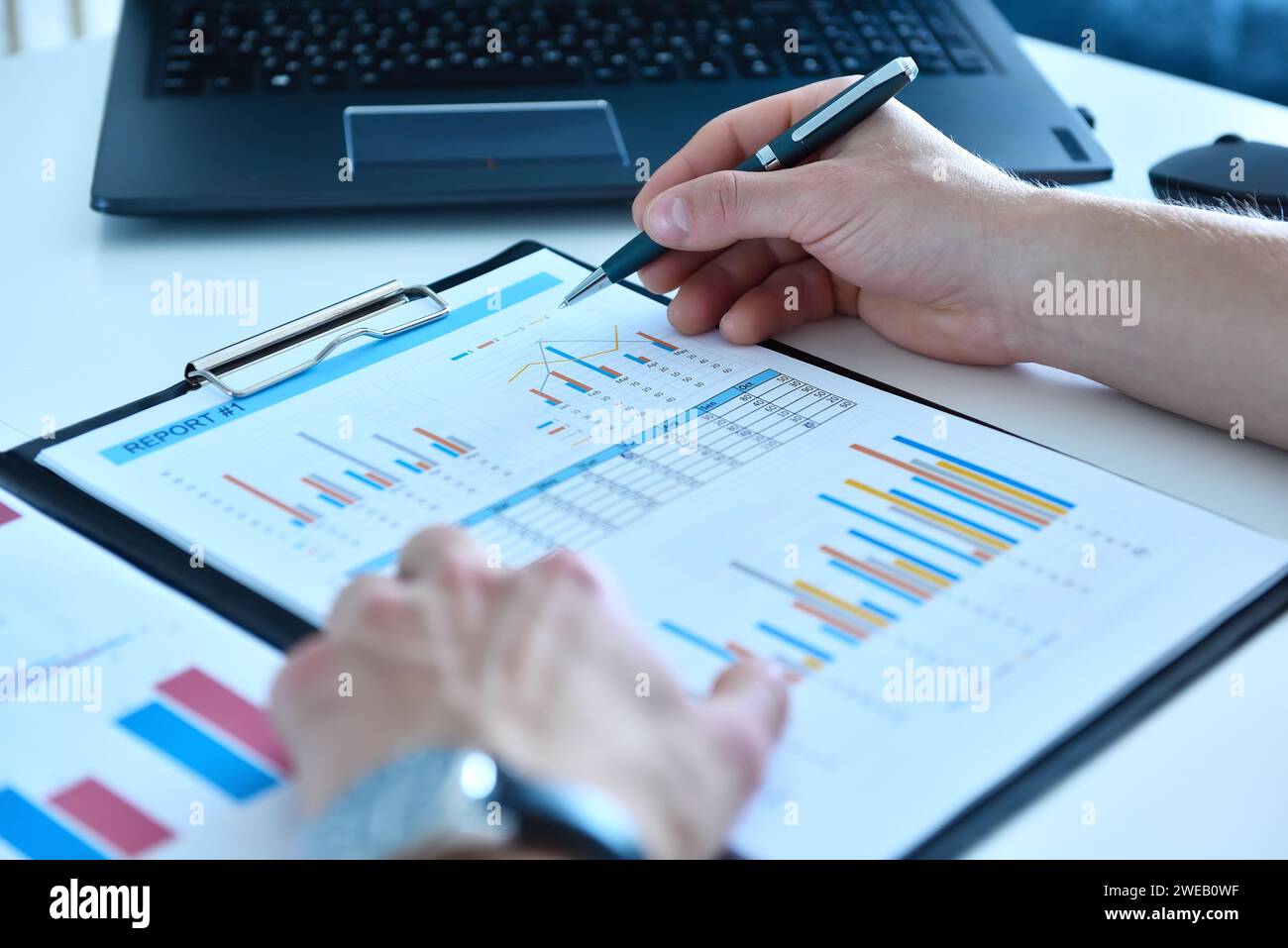 Accountant man hands with pen analyzing business report and stock data ...