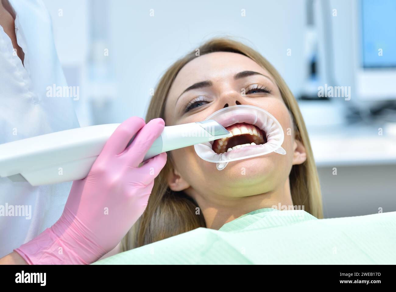 Woman dentist using dental intraoral scanner while examining patient ...