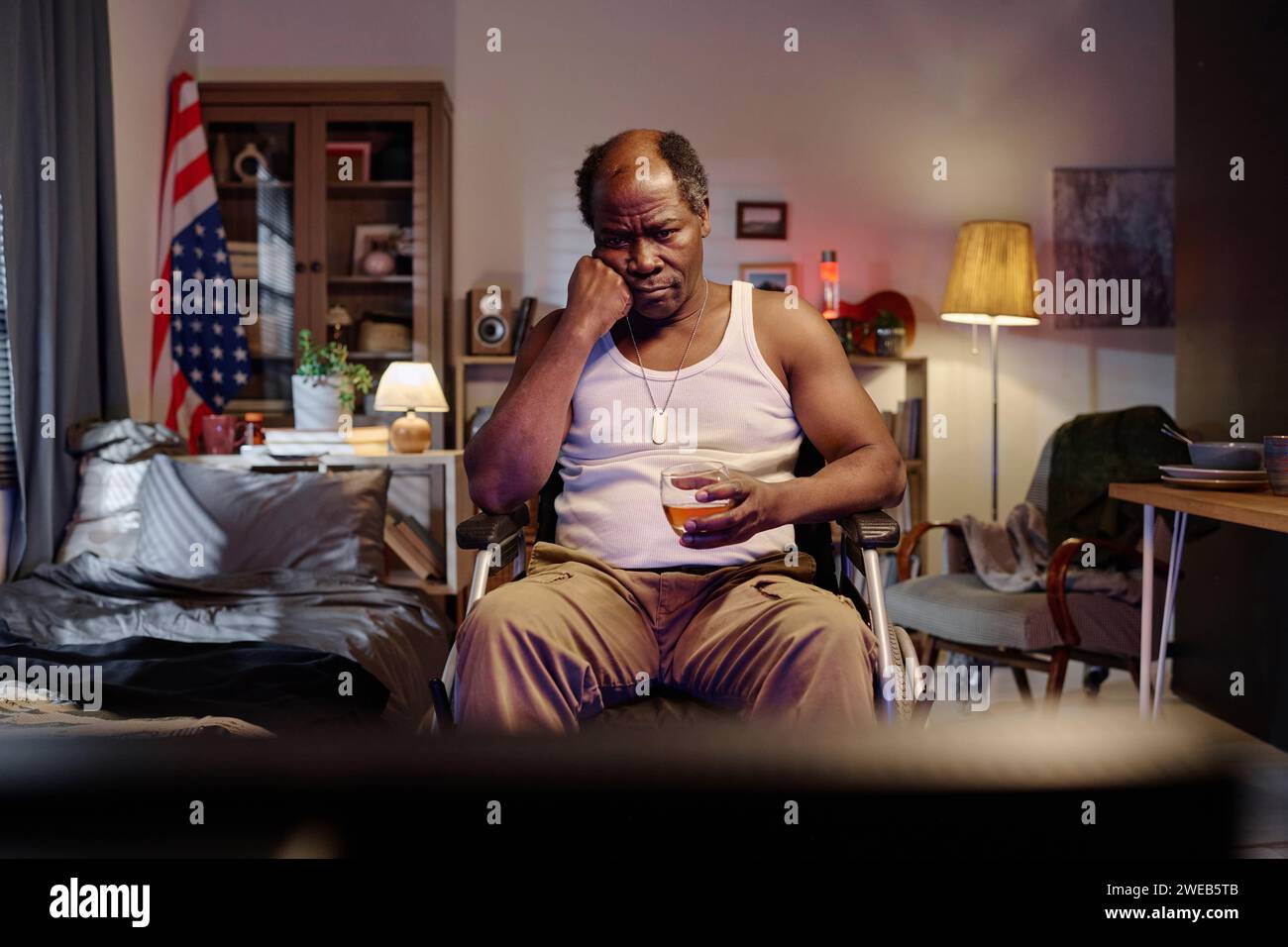 Black man sitting in front of television watching boring TV program and ...