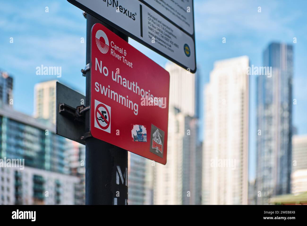 No unauthorised swimming sign, with Canary Wharf in the backdrop ...