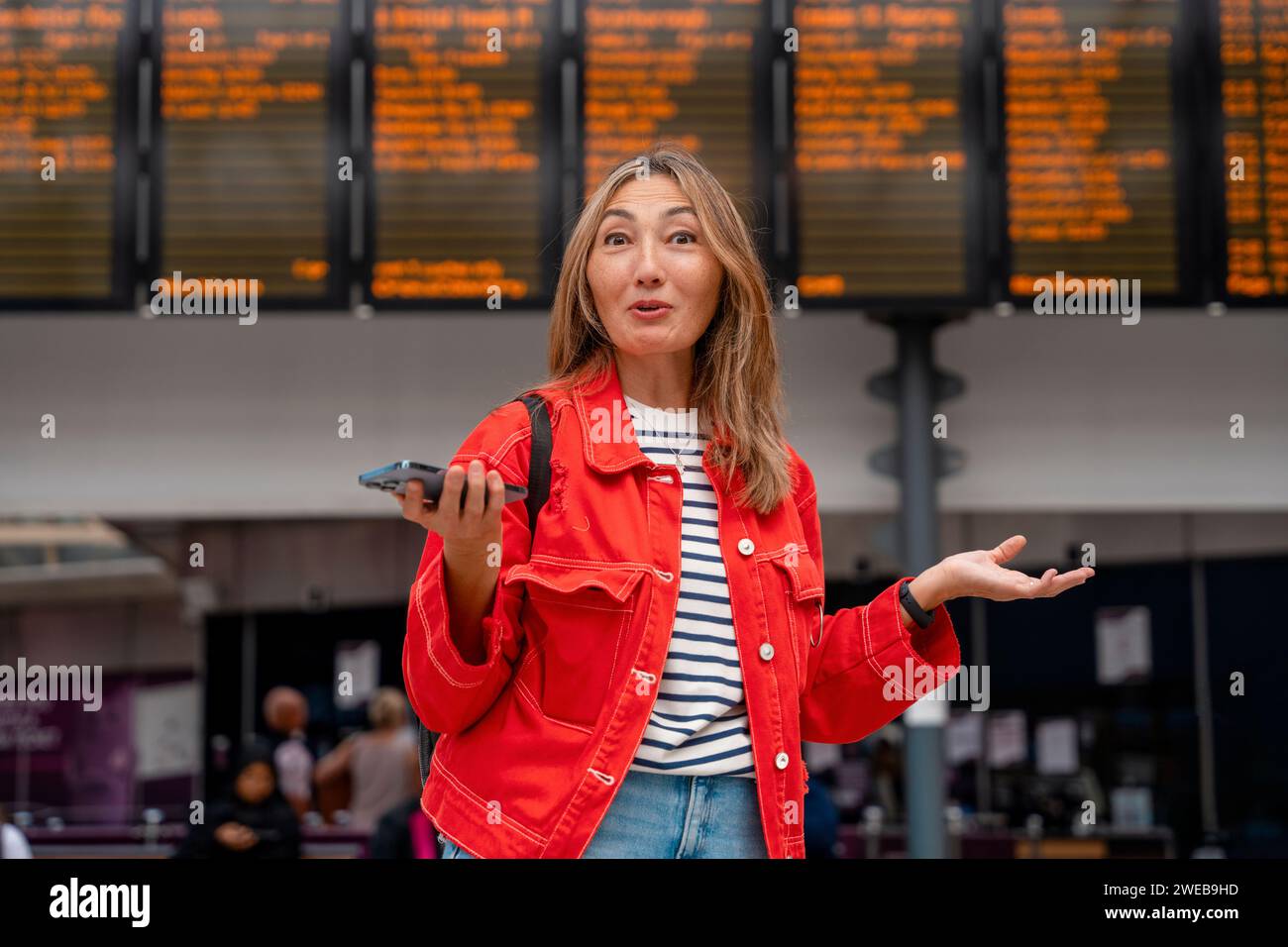 confused asian woman with backpack and holding smartphone while at the ...
