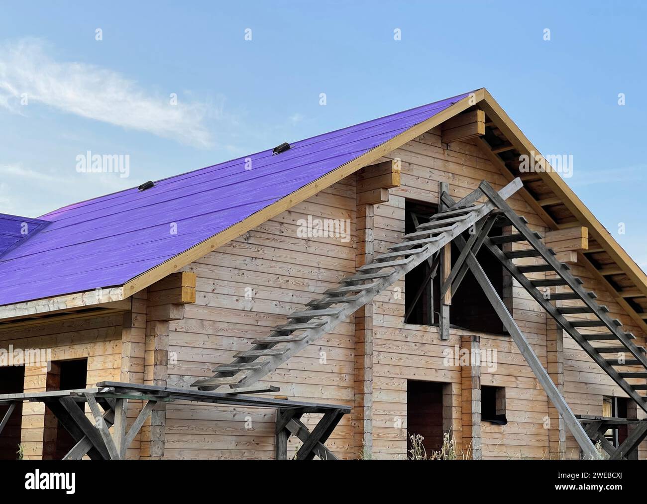 Construction of a wooden house and roof waterproofing Stock Photo - Alamy