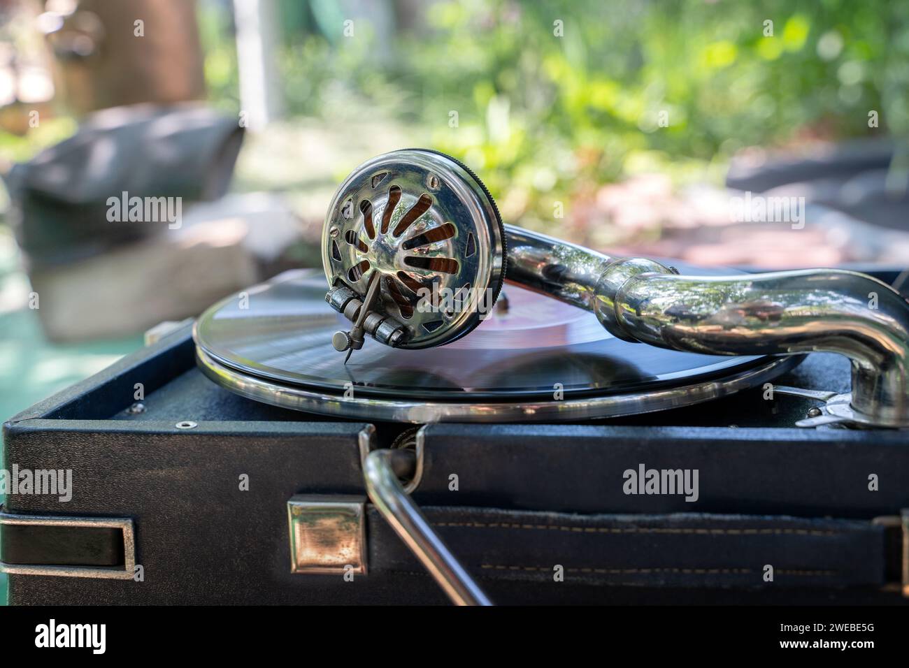 Vintage old record player gramophone needle on vinyl record. Round shiny metal needle holder ...
