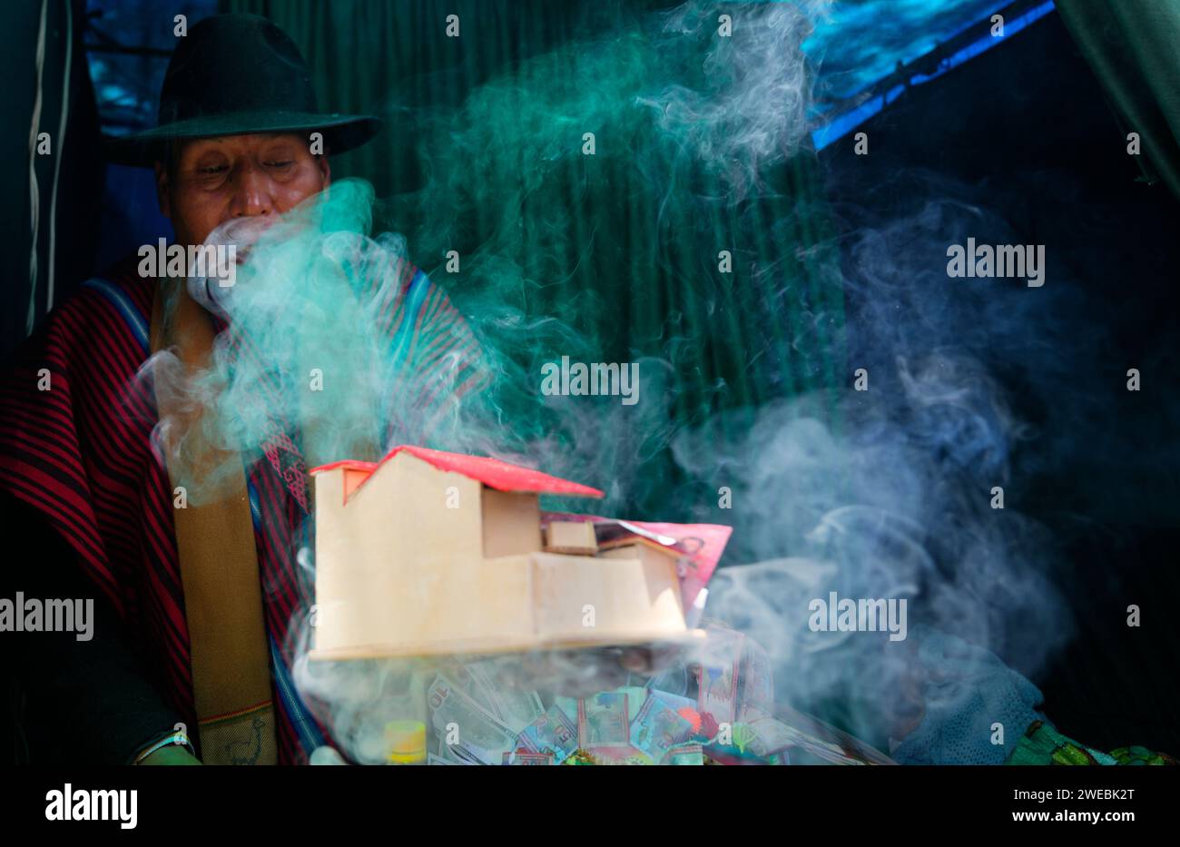 An Aymara Indigenous spiritual guide blesses a miniature home and bank ...