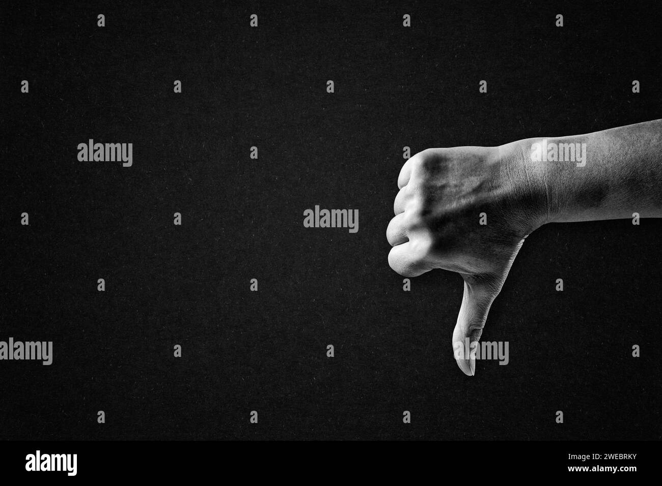 Hand Showing Thumb Down Dislike Sign in Black and White on Textured ...