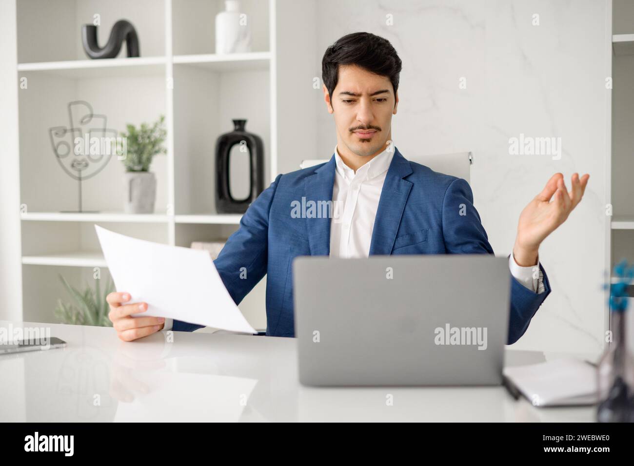 Hispanic businessman in a blue suit expressing confusion or concern ...