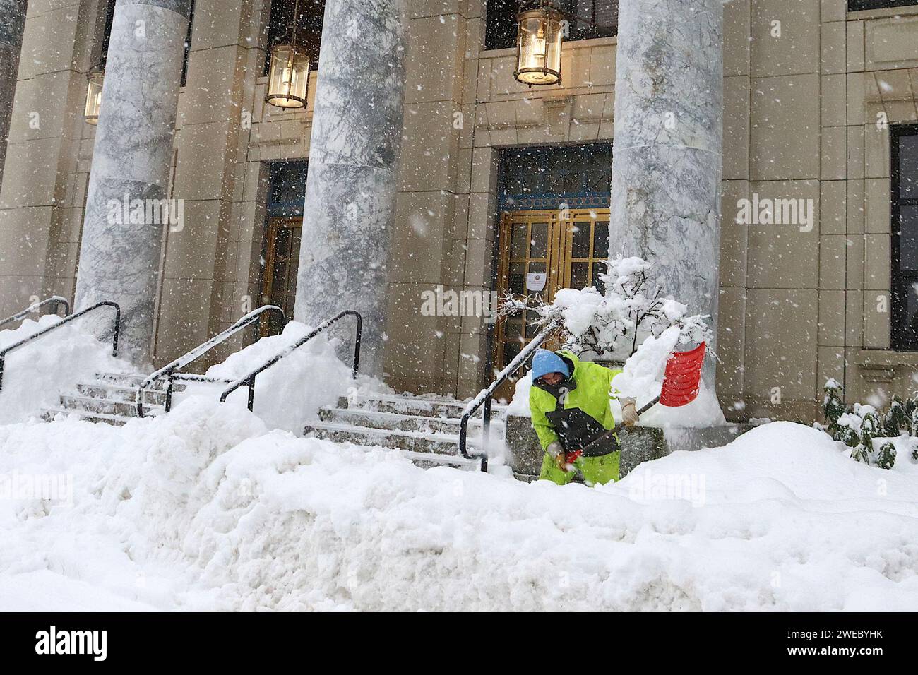 Jason Skidmore shovels snow along the sidewalk in front of the Alaska ...