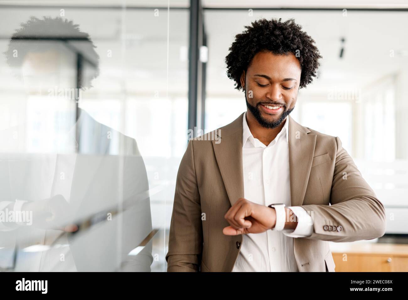 A businessman checks the time on his smartwatch in a well-appointed ...