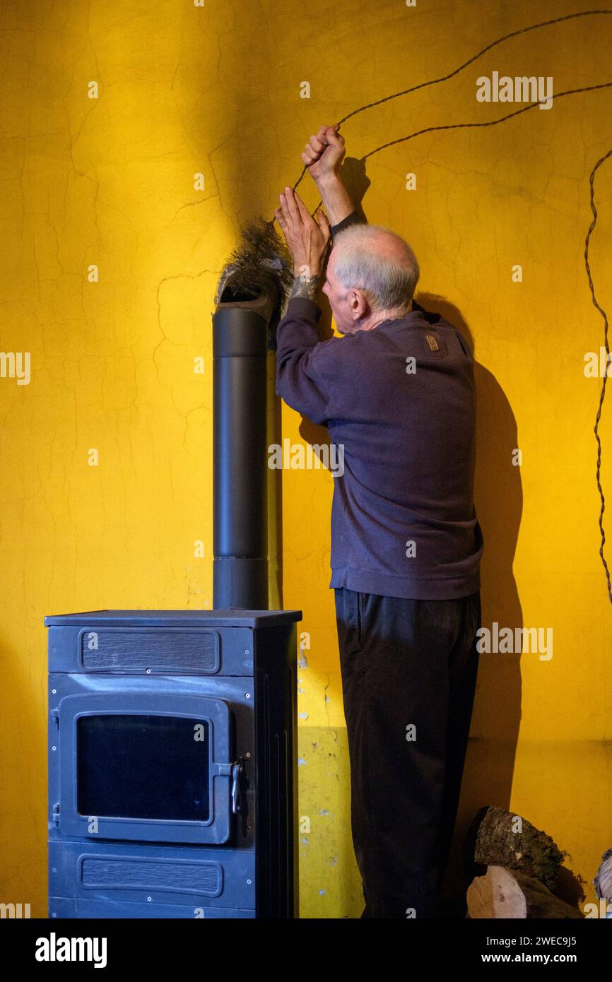 mature older male man cleaning the chimney flue using wire brush to ...