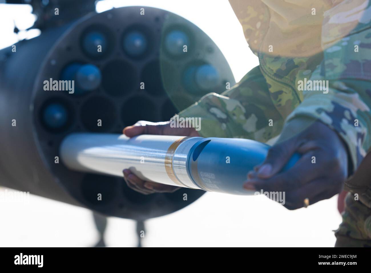 U.S. Army Soldier loads a flechette rocket into the rocket pod of an AH ...